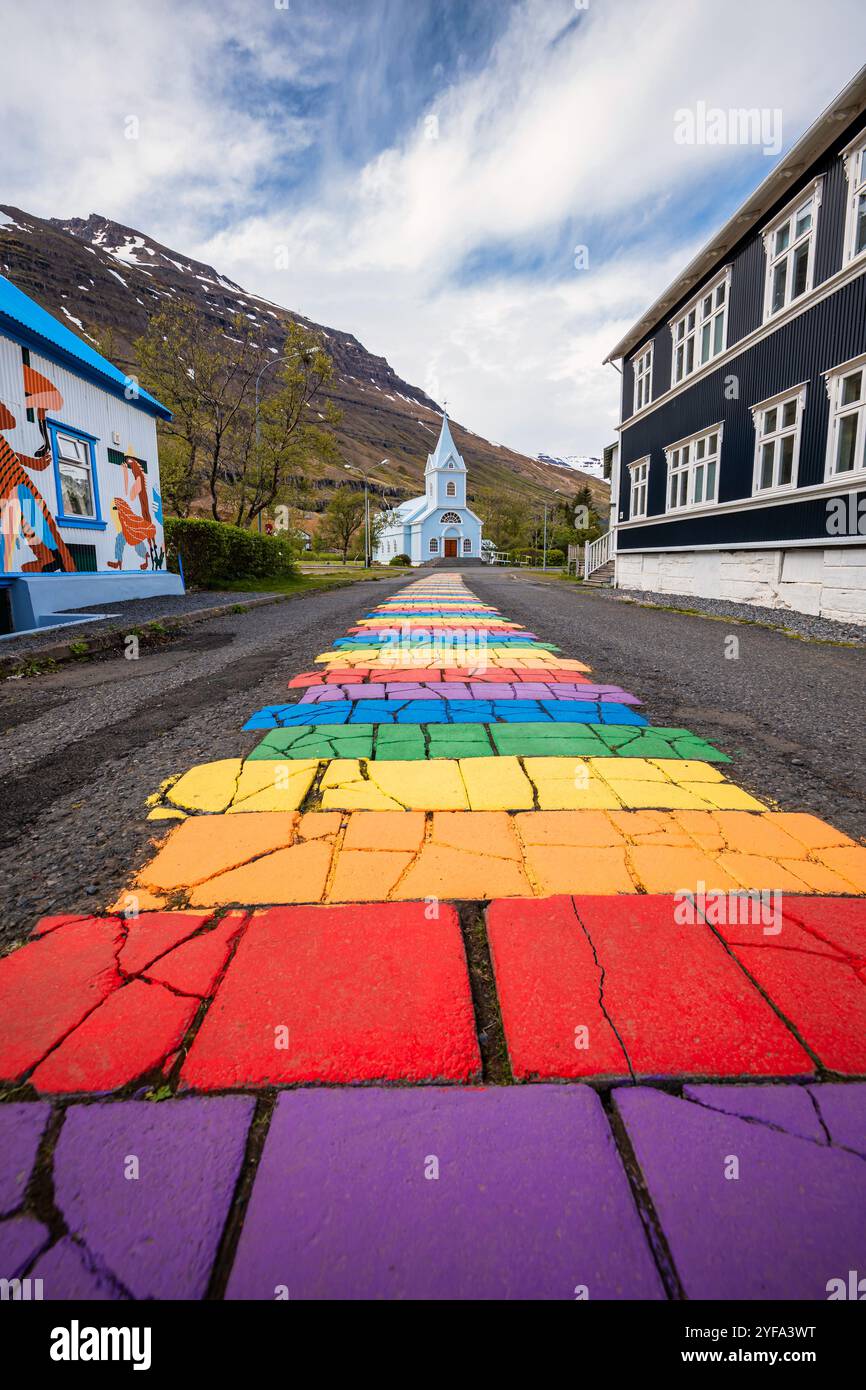 The famous rainbow road in Seydisfjordur with icelandic buildings ...