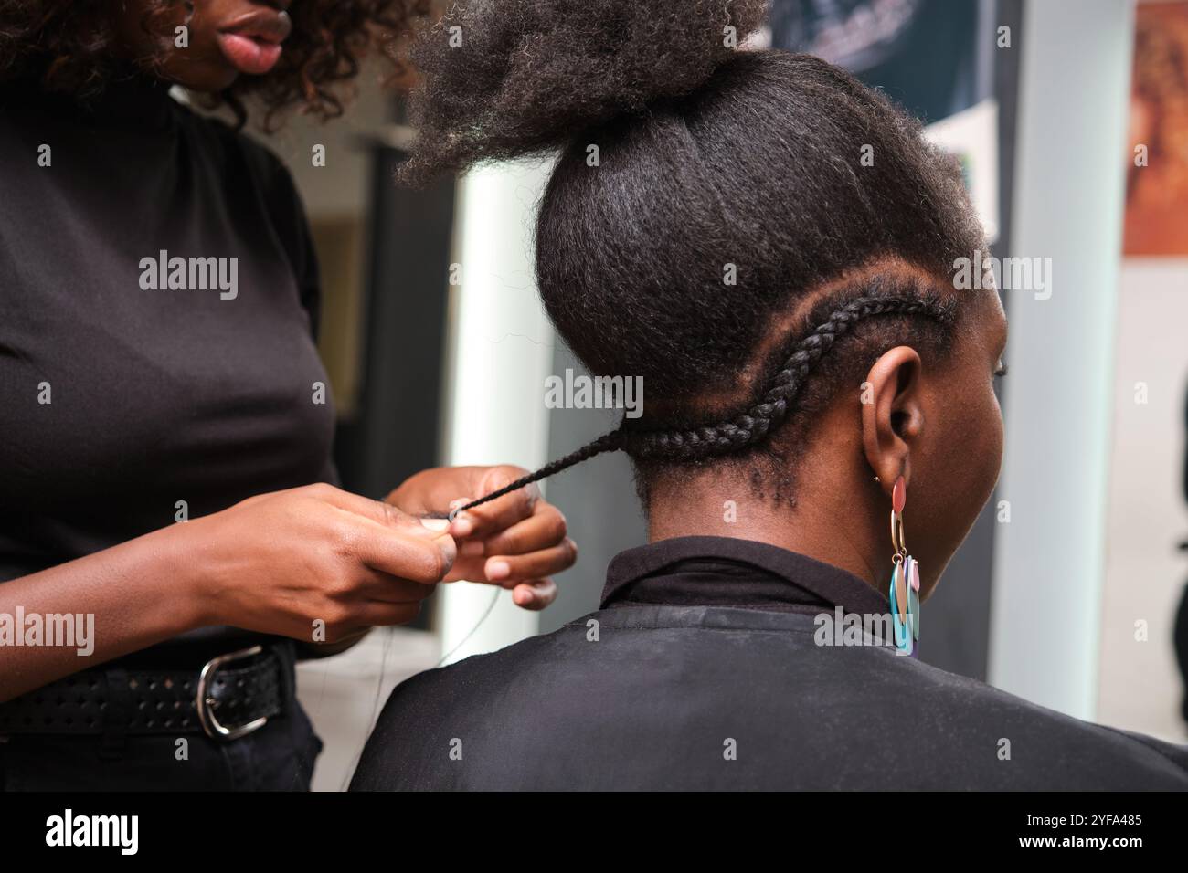 Hairdresser braiding client's afro hair in salon Stock Photo - Alamy
