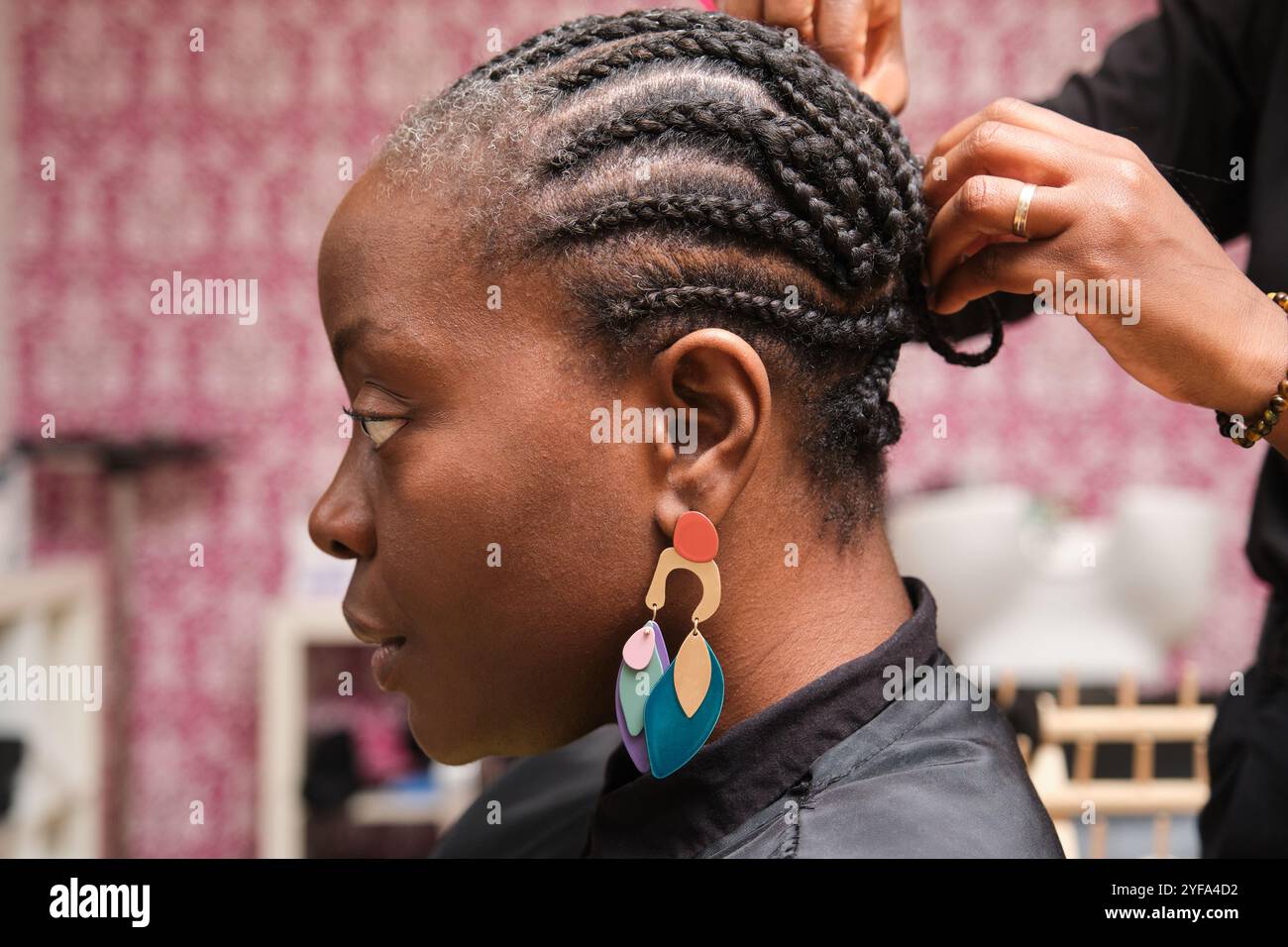 Hairdresser braiding crochet braids on client in afro hair salon Stock ...