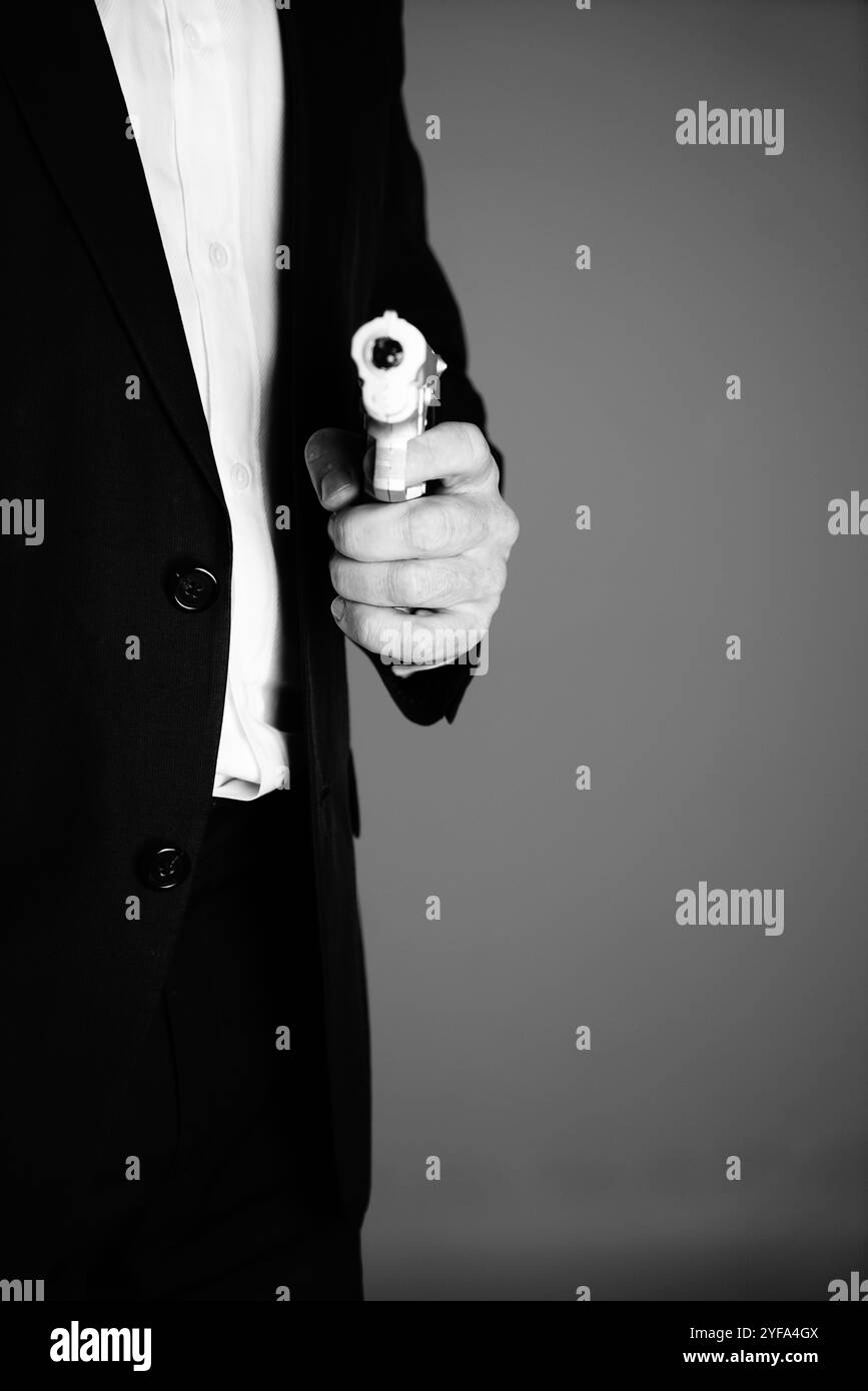 Retro secret agent with pistol revolver gun in hand in vintage crime ...