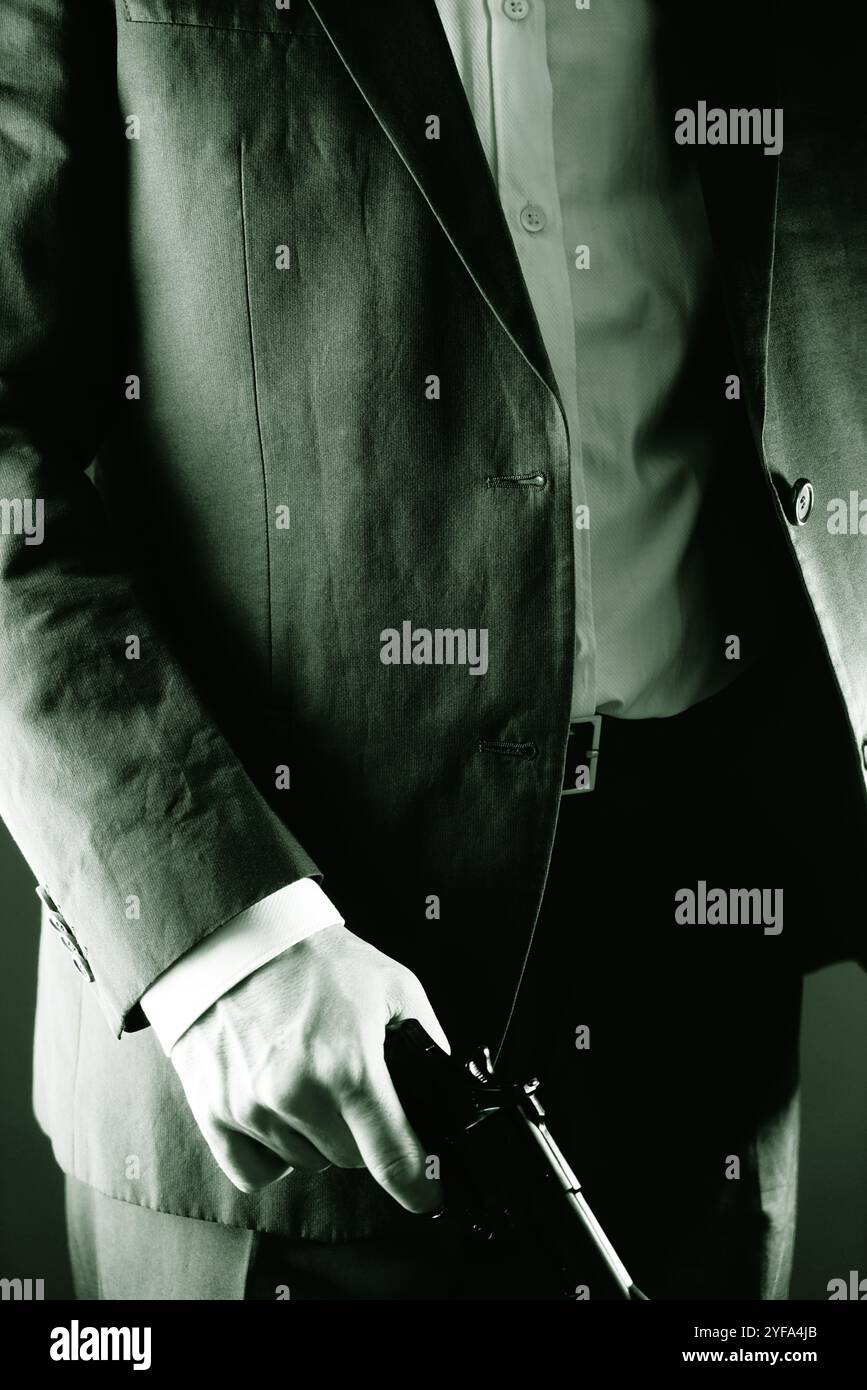 Retro secret agent with pistol revolver gun in hand in vintage crime ...