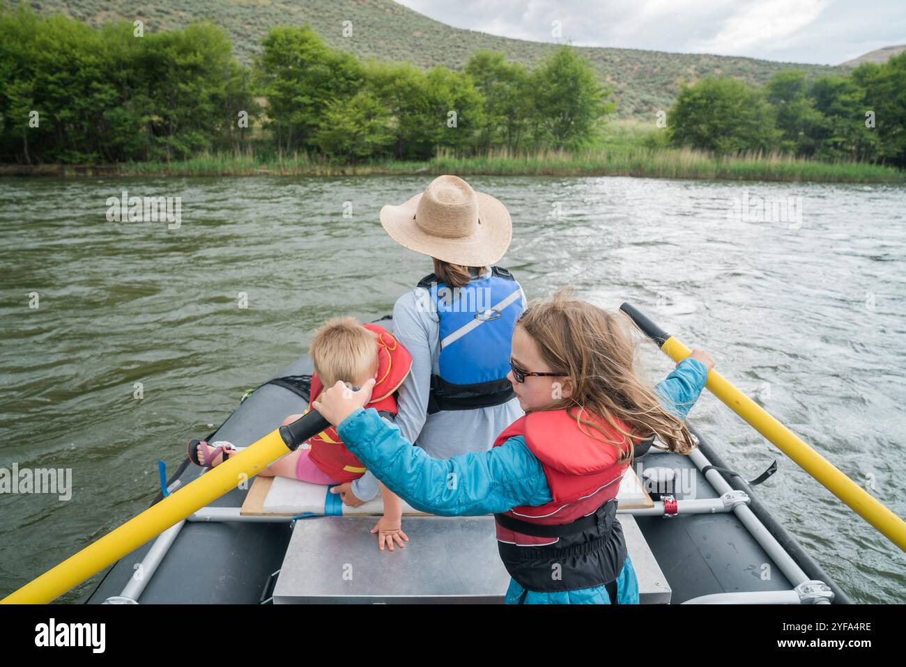 A 6 year-old girl paddles an oar raft on a river Stock Photo - Alamy