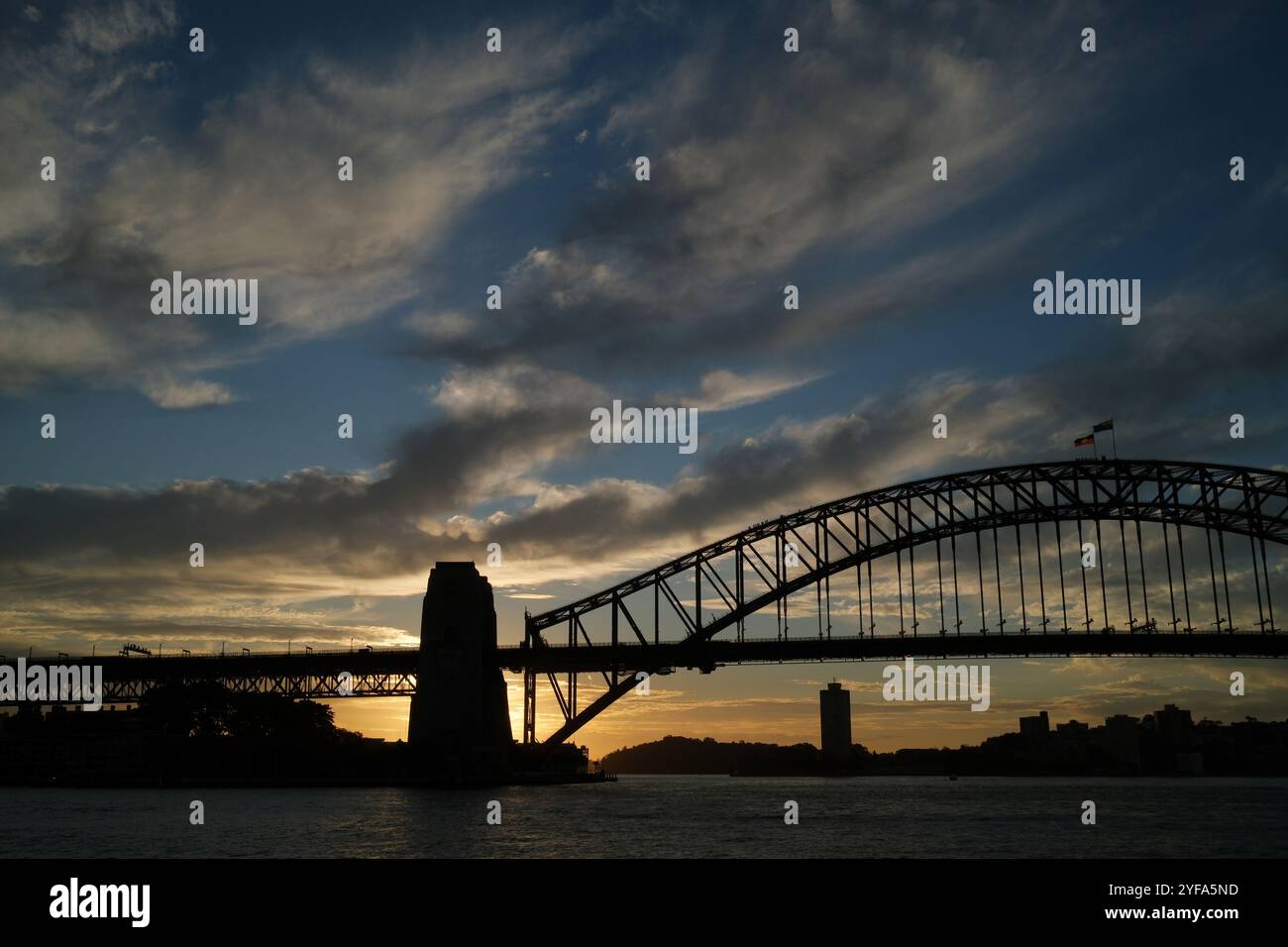 Silhouette of the Sydney Harbour Bridge, flags flying at dusk, bridge ...