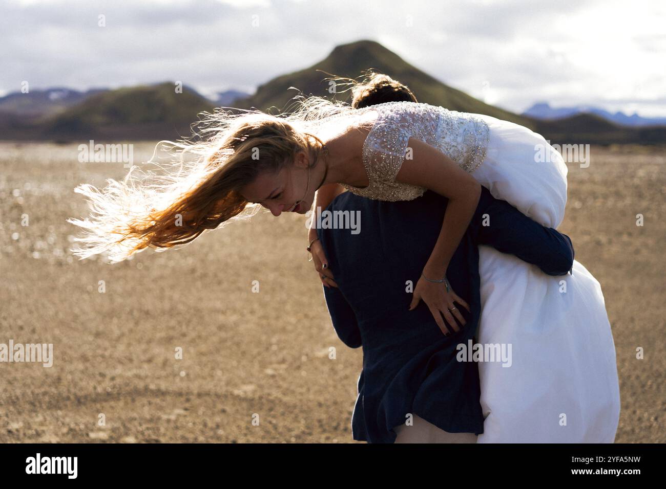 The groom carries the bride on his shoulder Stock Photo - Alamy