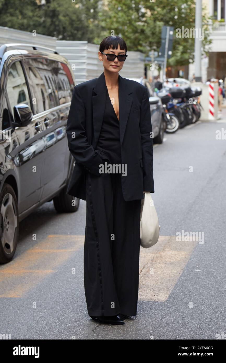 MILAN, ITALY - SEPTEMBER 19, 2024: Woman in black before Maison Margiela fashion show, Milan ...