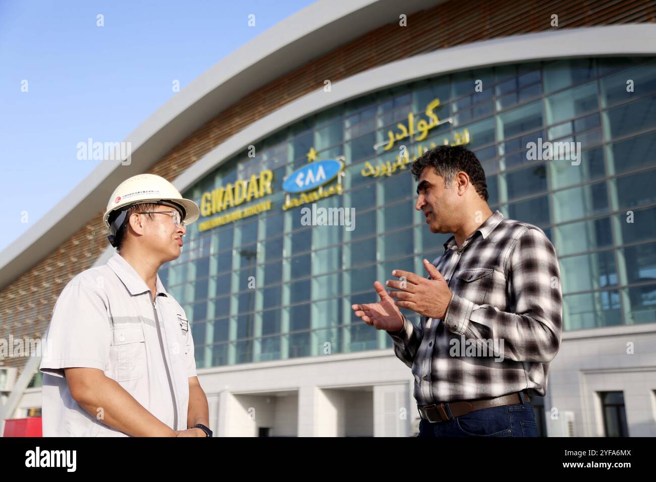 Gwadar, Pakistan. 13th Sep, 2024. Khalid Kakar (R), airport manager of Gwadar Airport, talks ...
