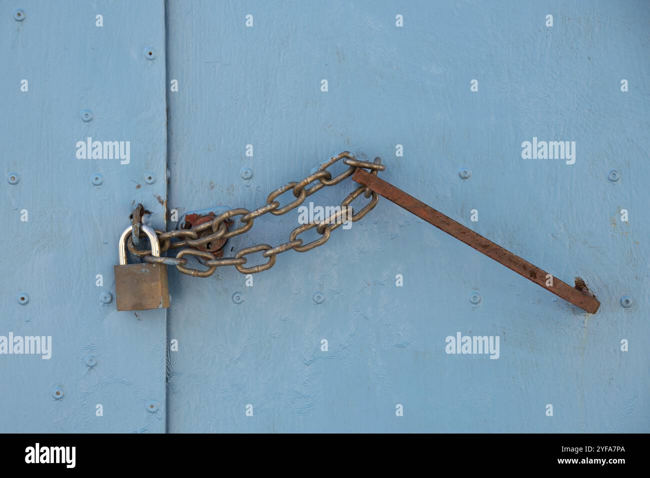 Blue closed metal door with locker iron chain for safety. Keep safe for ...