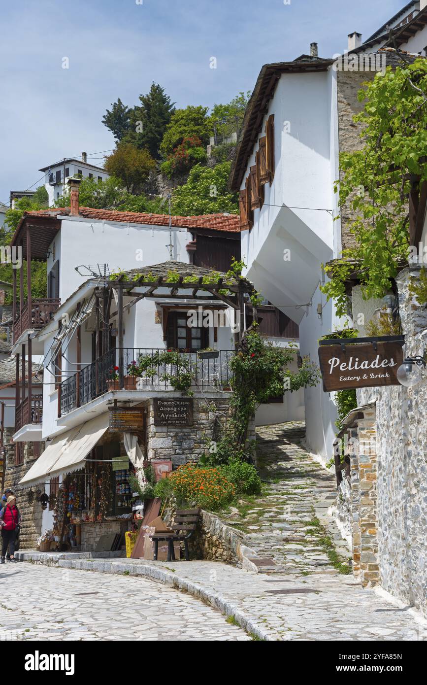 Picturesque street with stone house, wooden veranda and shops, embedded ...