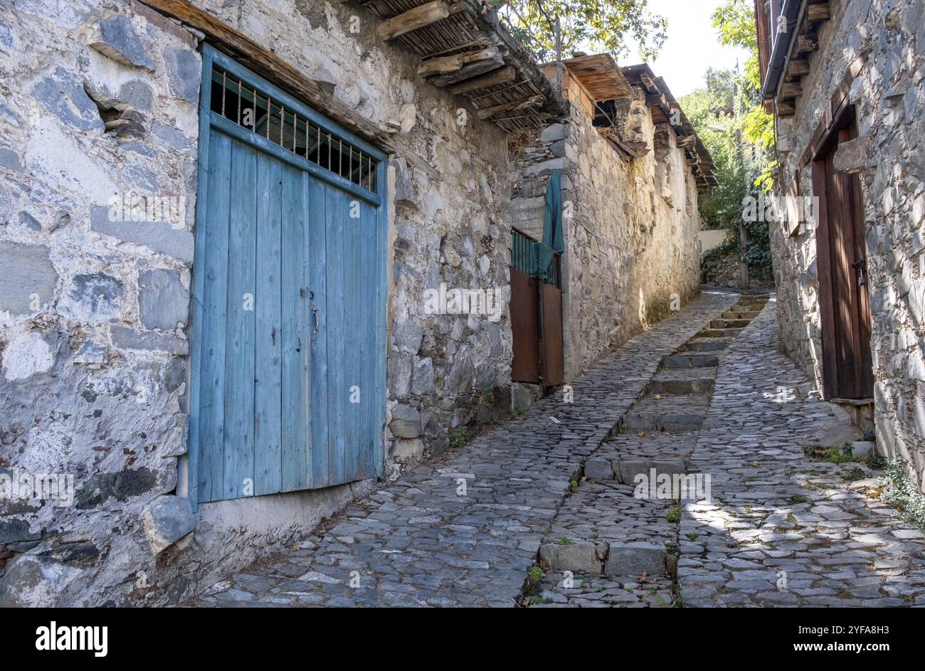 Stoned footpath crossing a traditional village. Stoned houses with ...