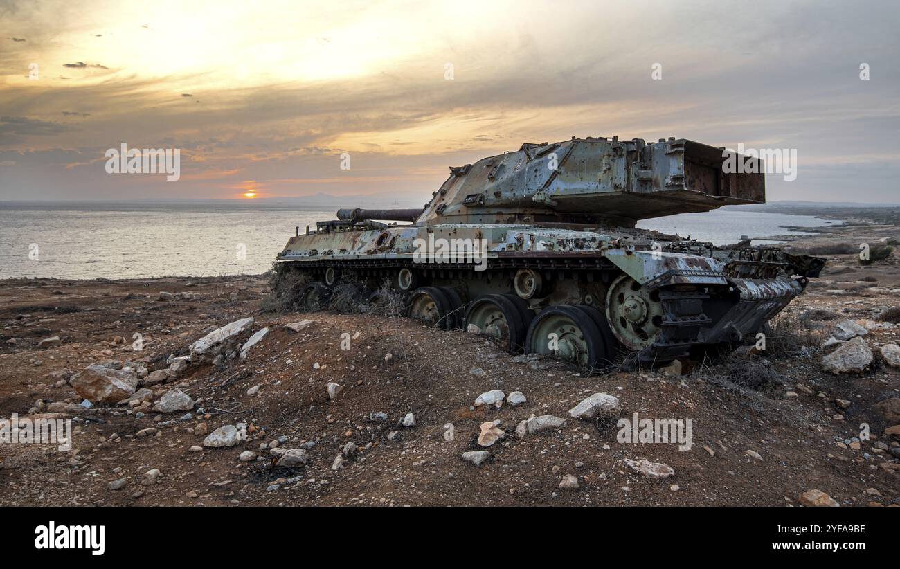 Abandoned military army tank vehicle at sunset in the coast ...