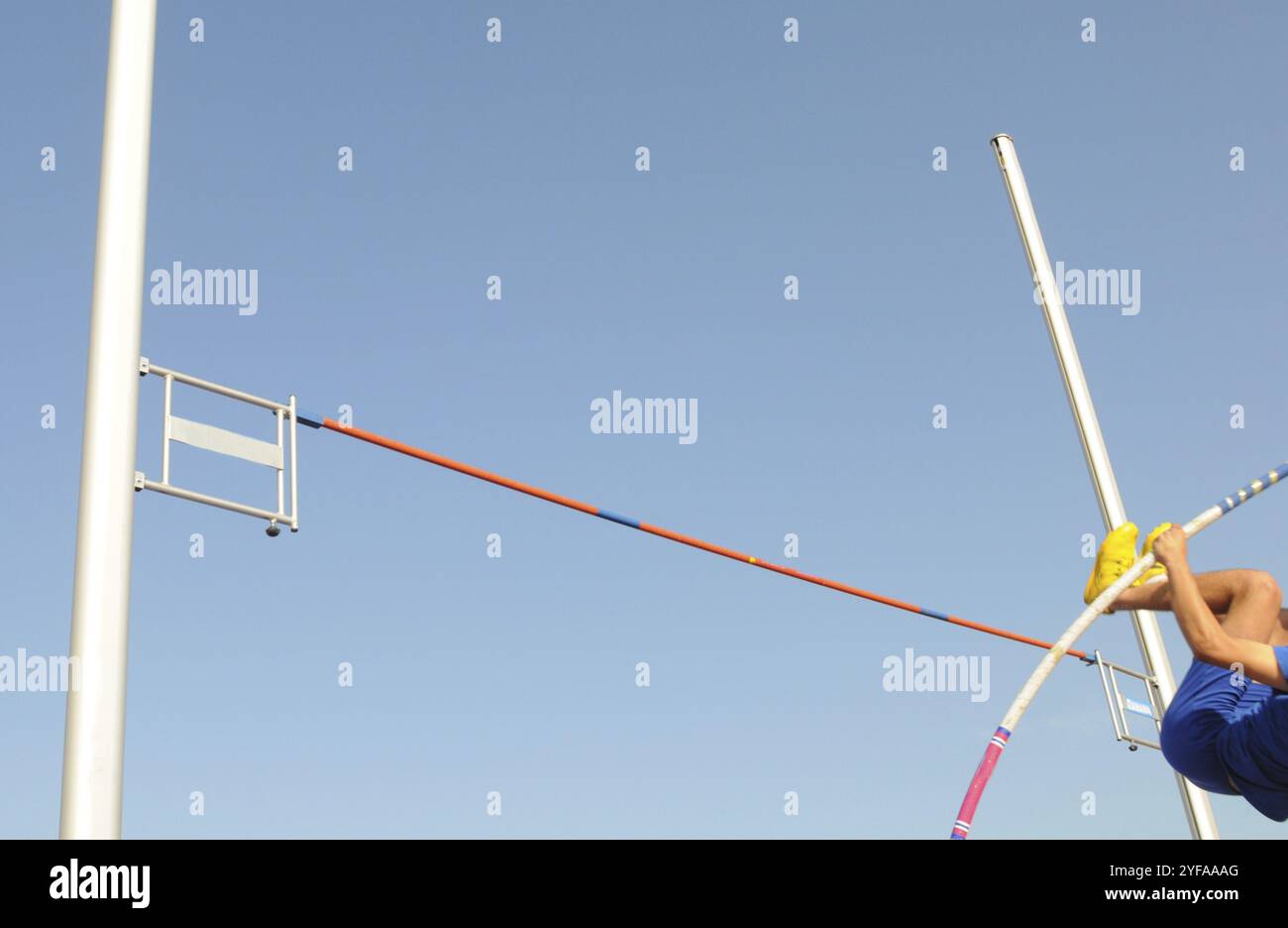 Pole vaulting. An Athlete in the middle of the vaulting phase during an ...