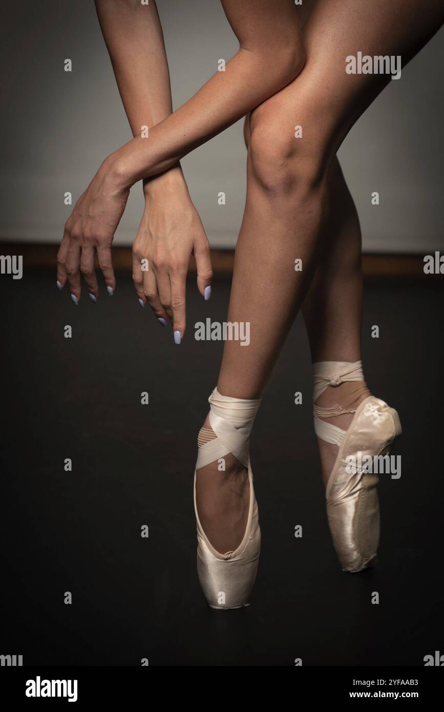 Beautiful legs of young ballerina with pointe shoes dancing on a black ...