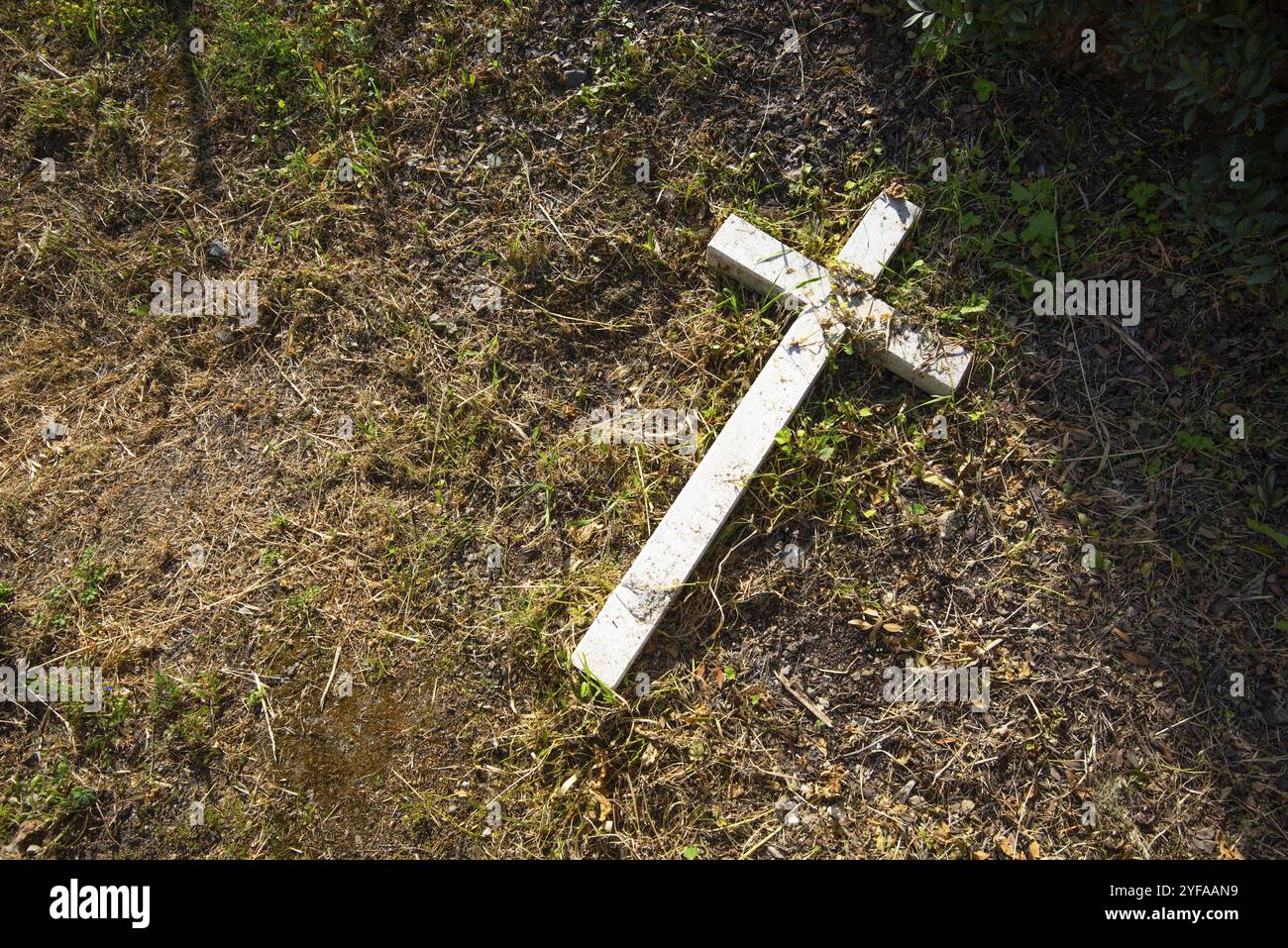 Devastated shattered stone concrete crucifix religious cross on ground ...