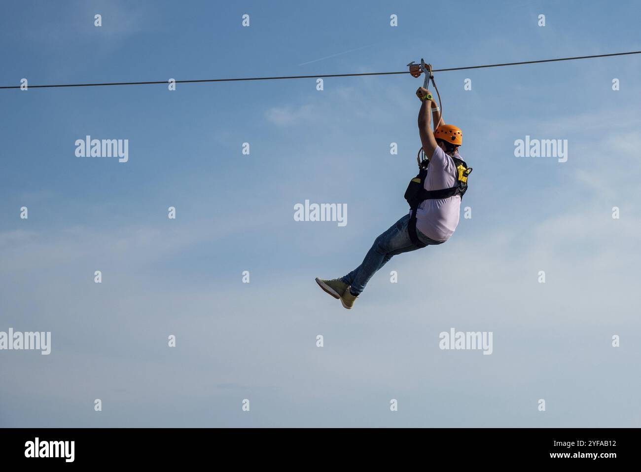 Zipline riders, Person on blue sky background, extreme leisure Stock ...