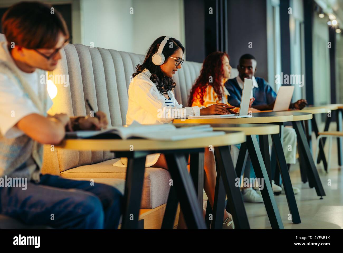 A vibrant college library scene with students engaged in studying ...