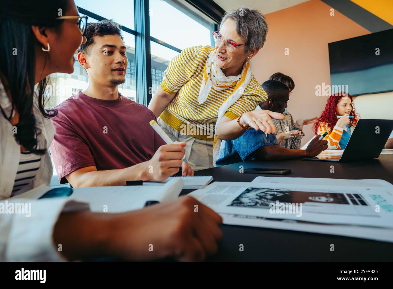 A college lecturer engaging with students, explaining concepts in a ...