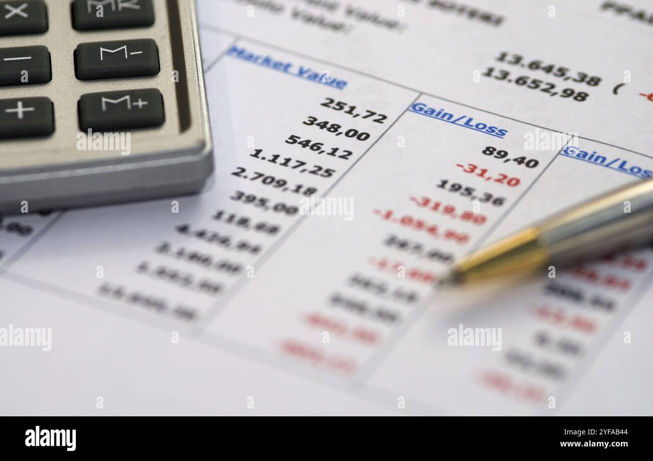 Financial report with pen and calculator Stock Photo - Alamy