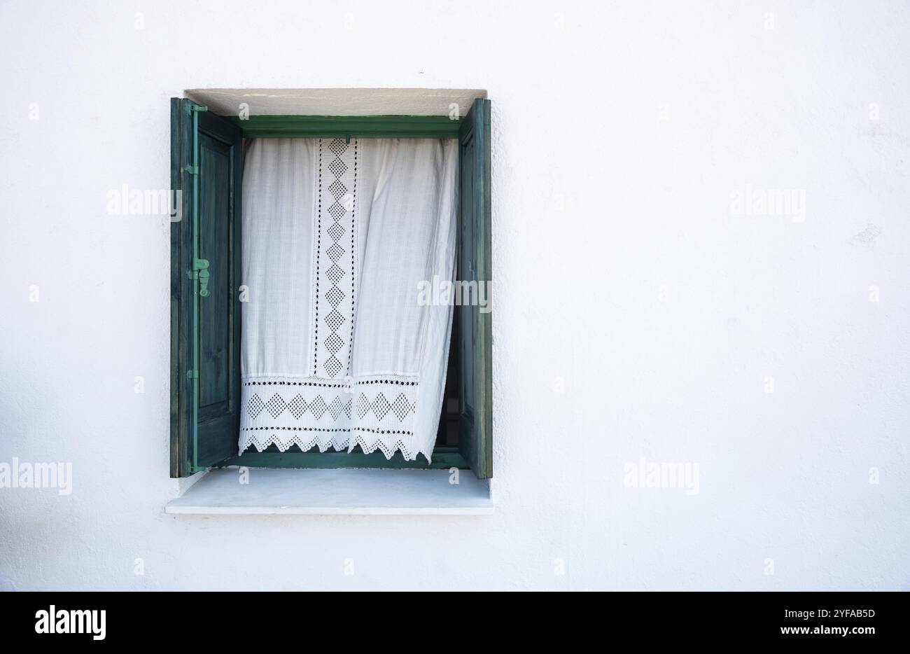Beautiful white traditional curtain waving through an open wooden green ...