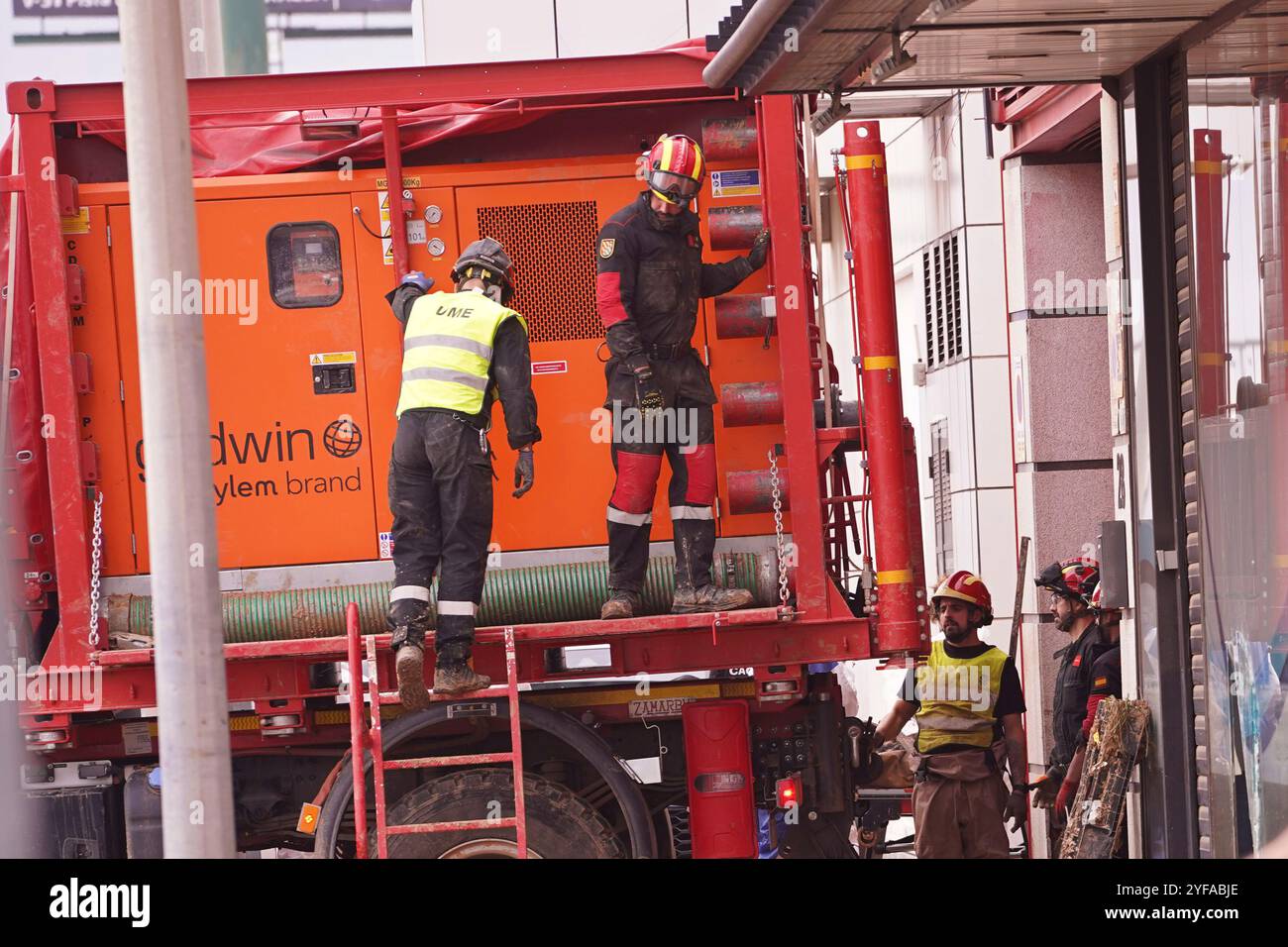 Military emergency unit (UME) personnel work to pump out water from an ...