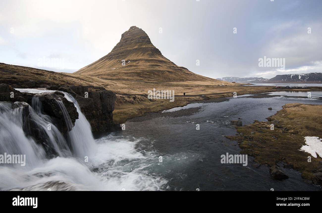 Kirkjufellsfoss waterfalls with the Kirkjufell mountain, at ...