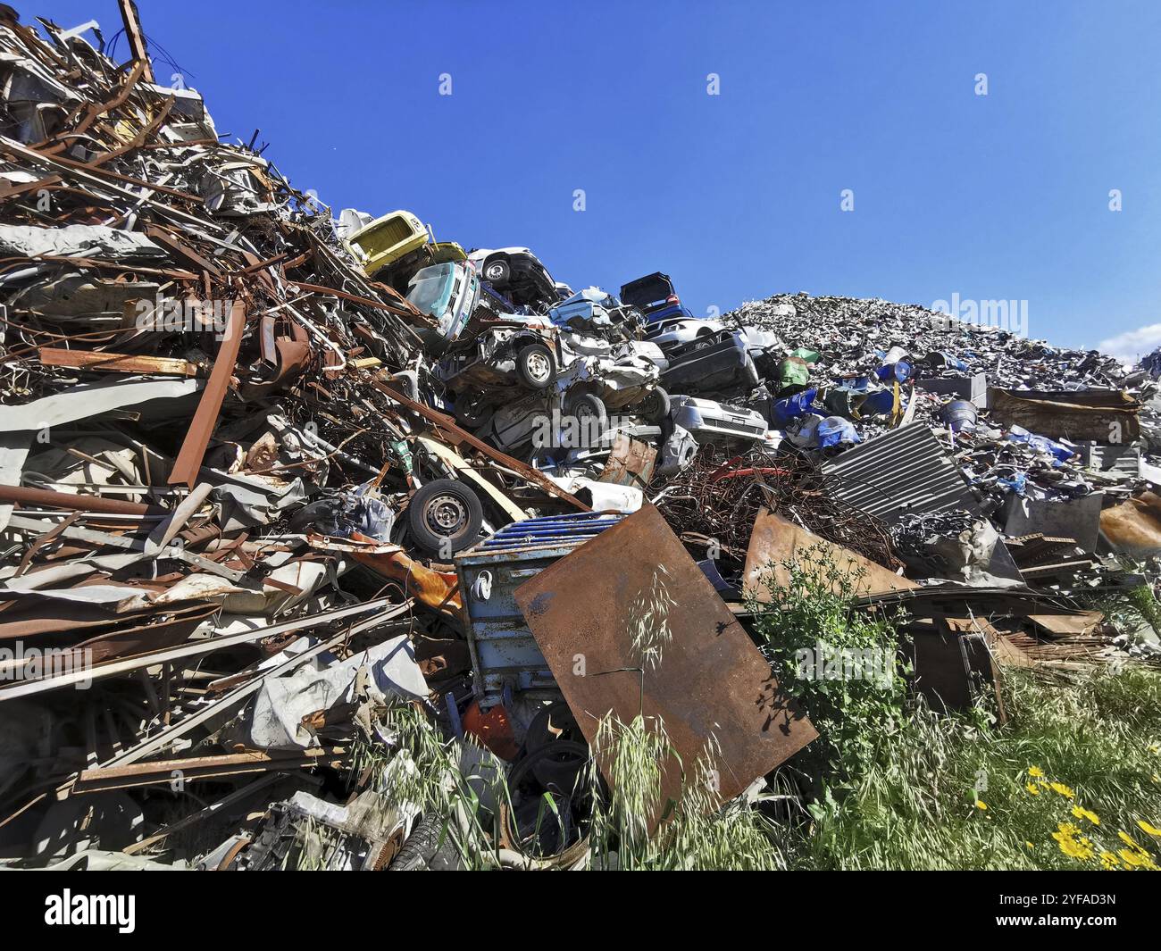 Pile of various scrap cars and other metals on a junk yard field ready recycling industry ...