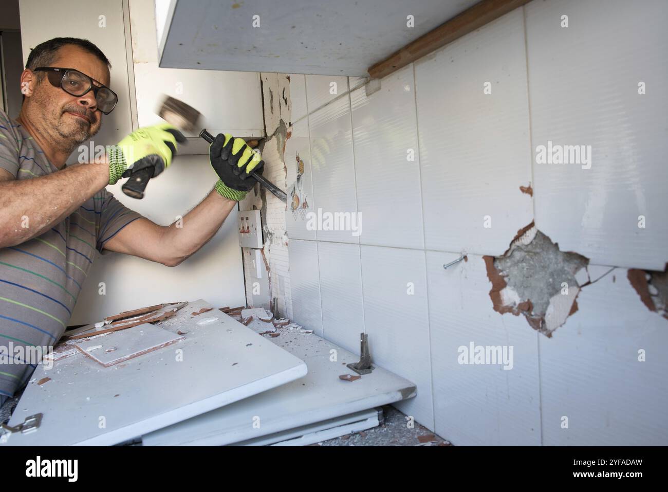 House kitchen Renovation. Old dirty wall tiles. Worker with breaking ...