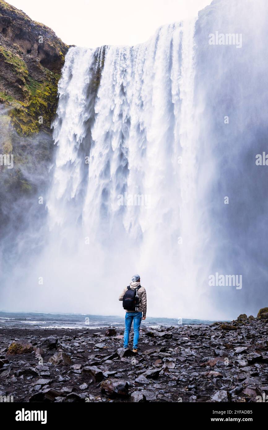 Man admiring the powerful skógafoss waterfall in Iceland breathtaking ...