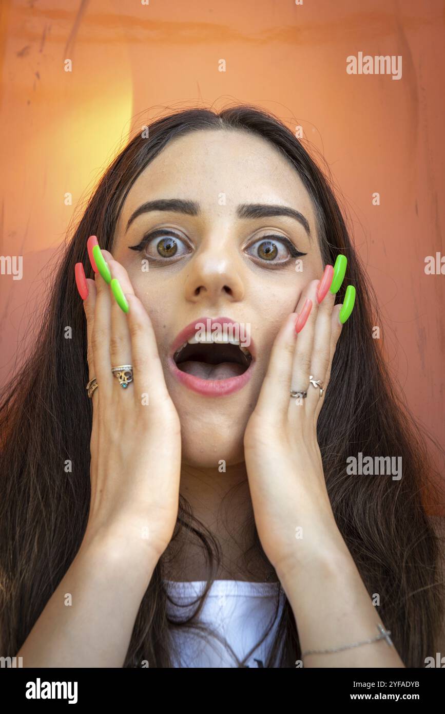 Surprised young woman holds hi-res stock photography and images - Alamy