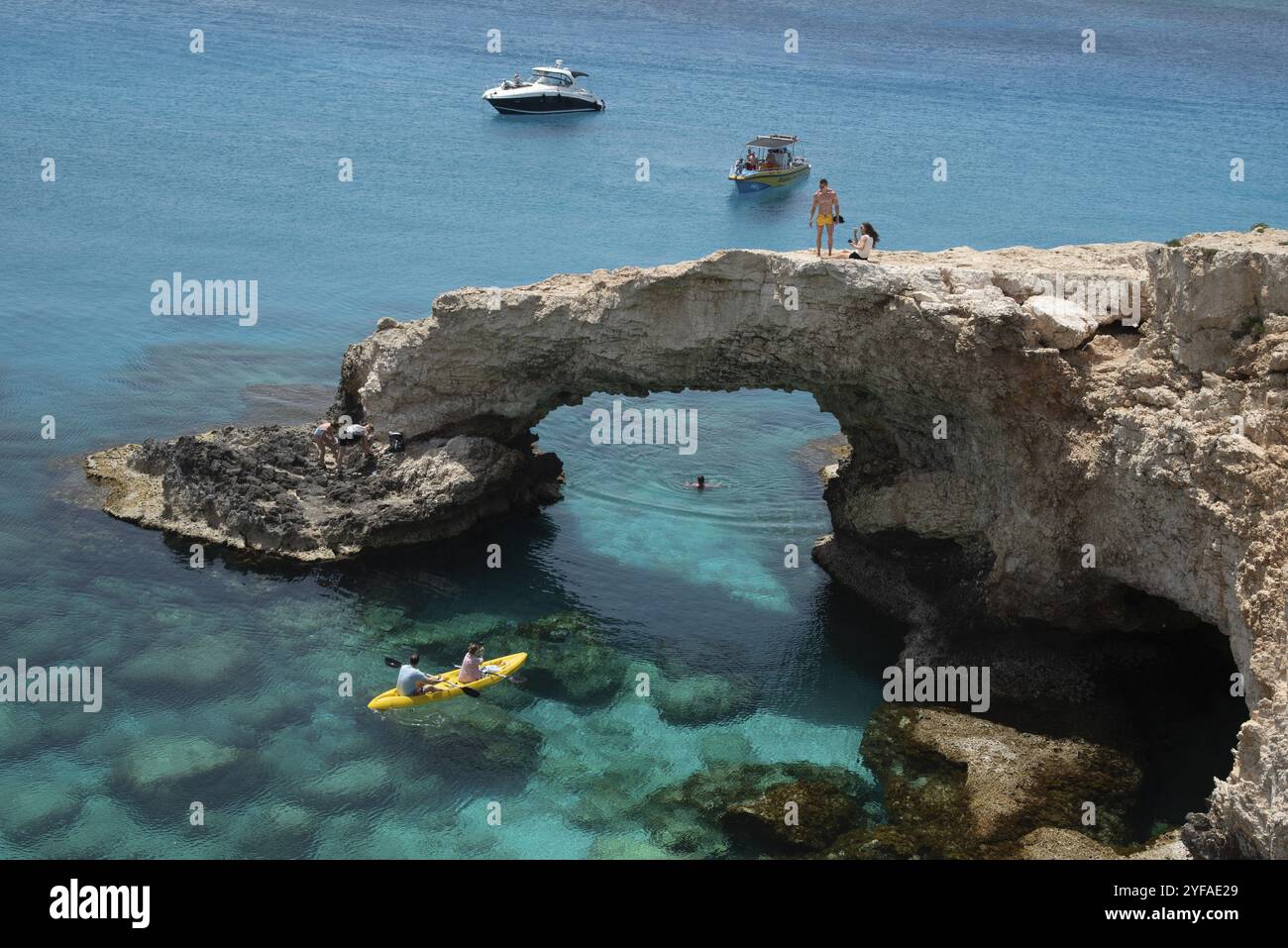 People standing above Sea caves on the famous lovers bridge, near Ayia ...