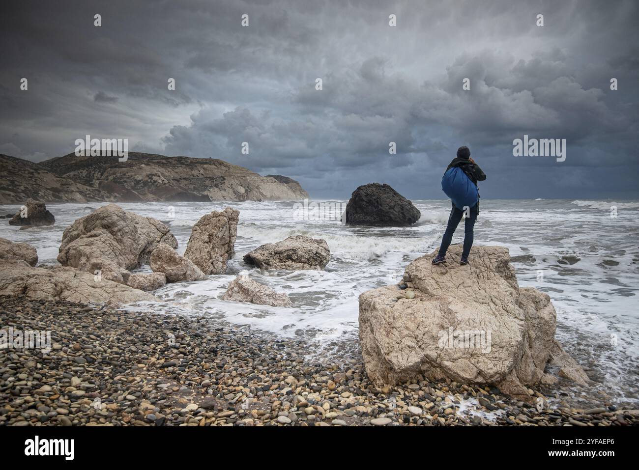 Unrecognised person standing at the rock and enjoying the stormy ...