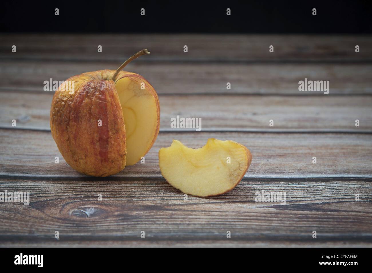 Red wilted rotten apple on a table. Bacteria infected rotten fruit ...