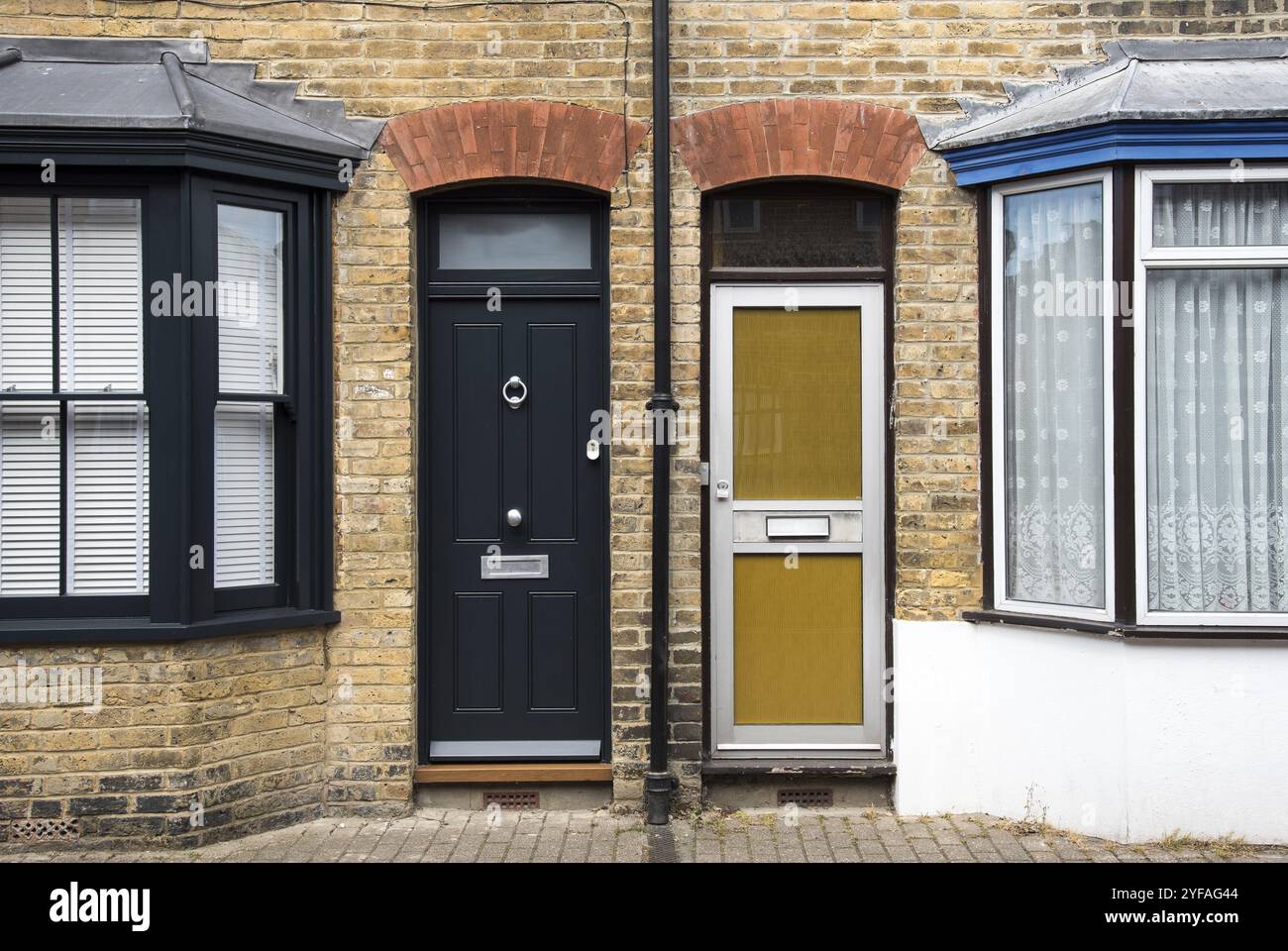 Traditional English house front entrance with closed doors and windows ...