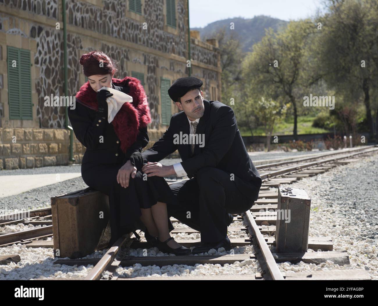 Young couple woman crying and in deep thoughts siting on the trainlines ...