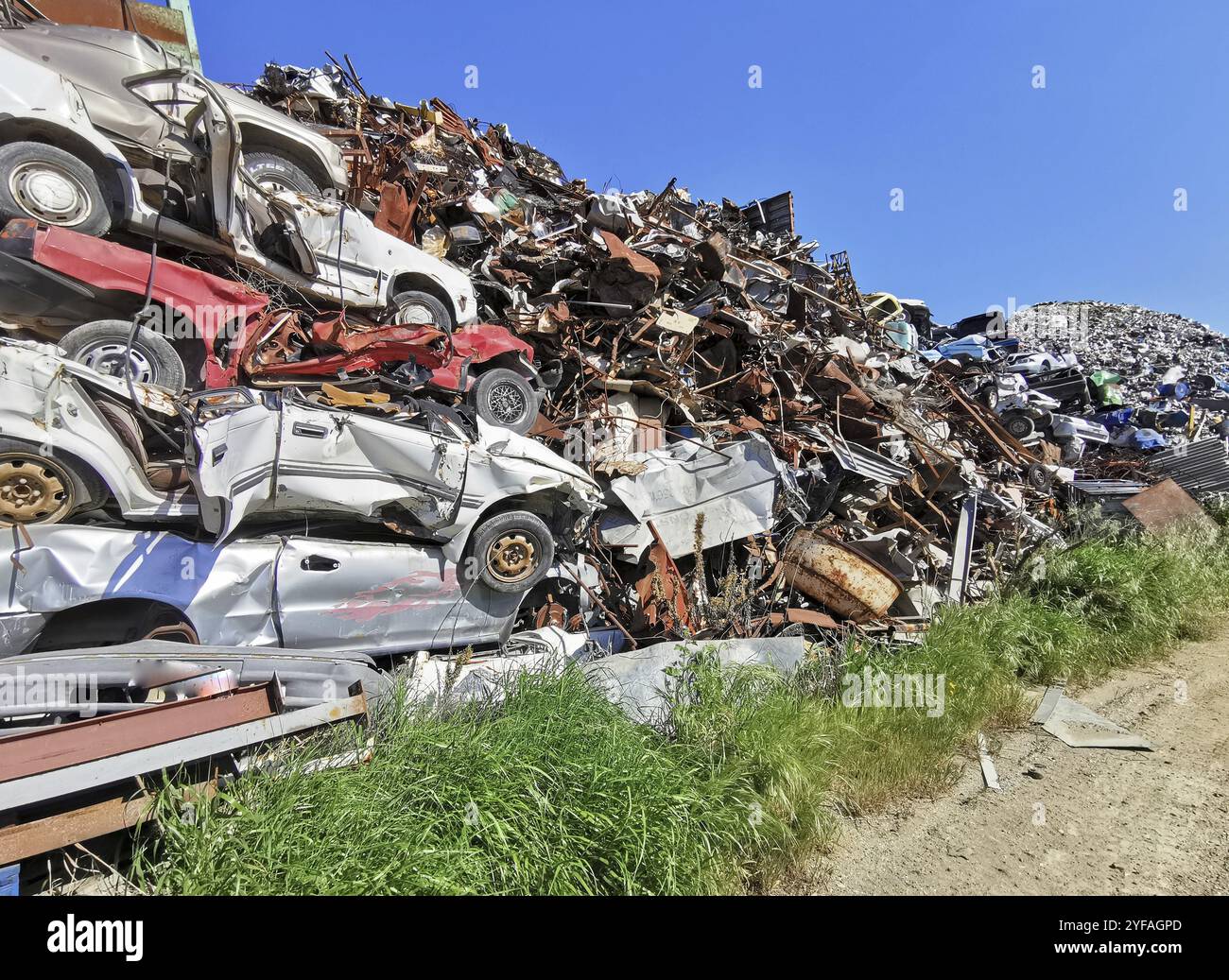 Pile of various scrap cars and other metals on a junk yard field ready ...