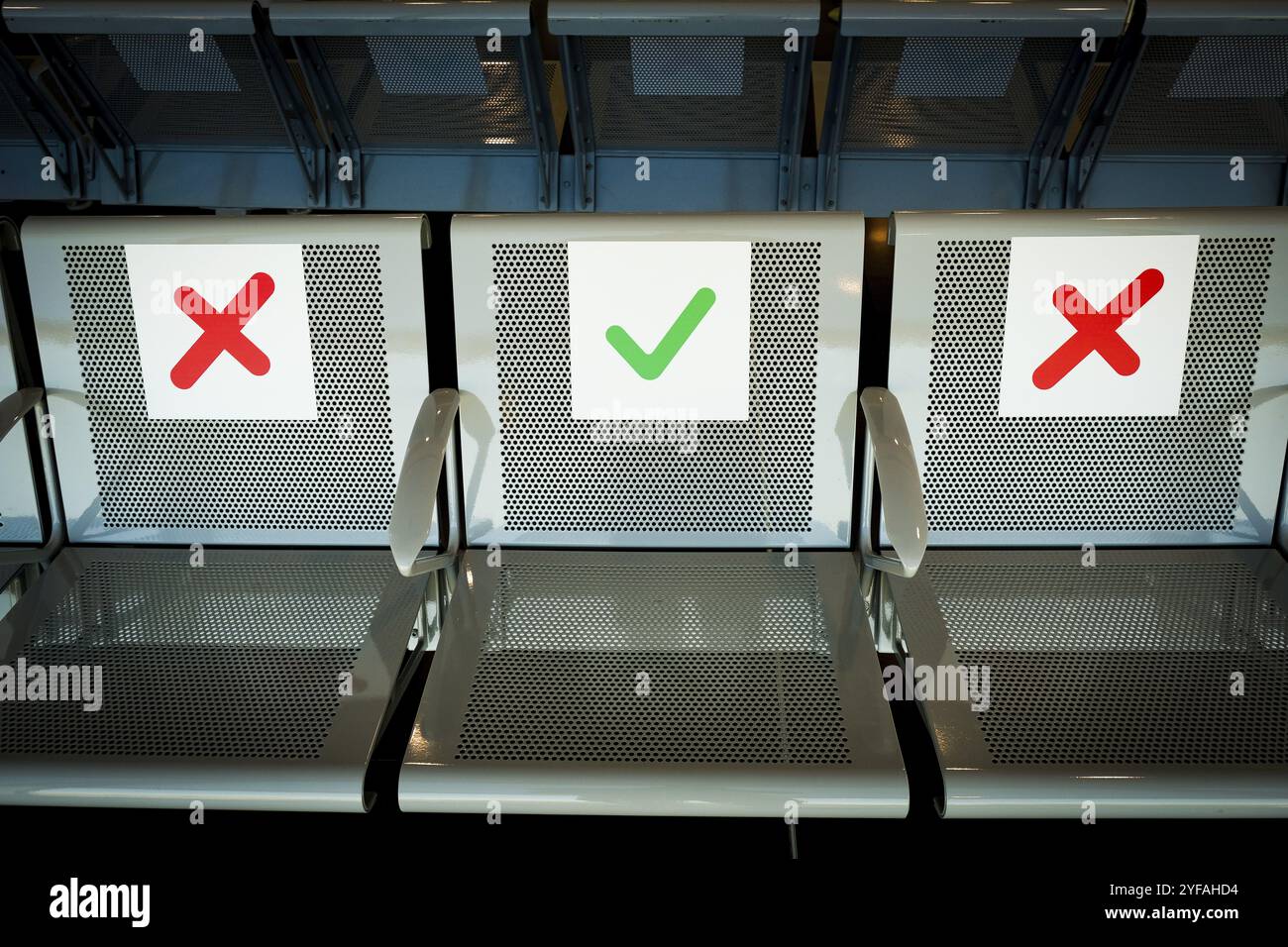 Empty chairs on an airport terminal with signs to keep social distance ...