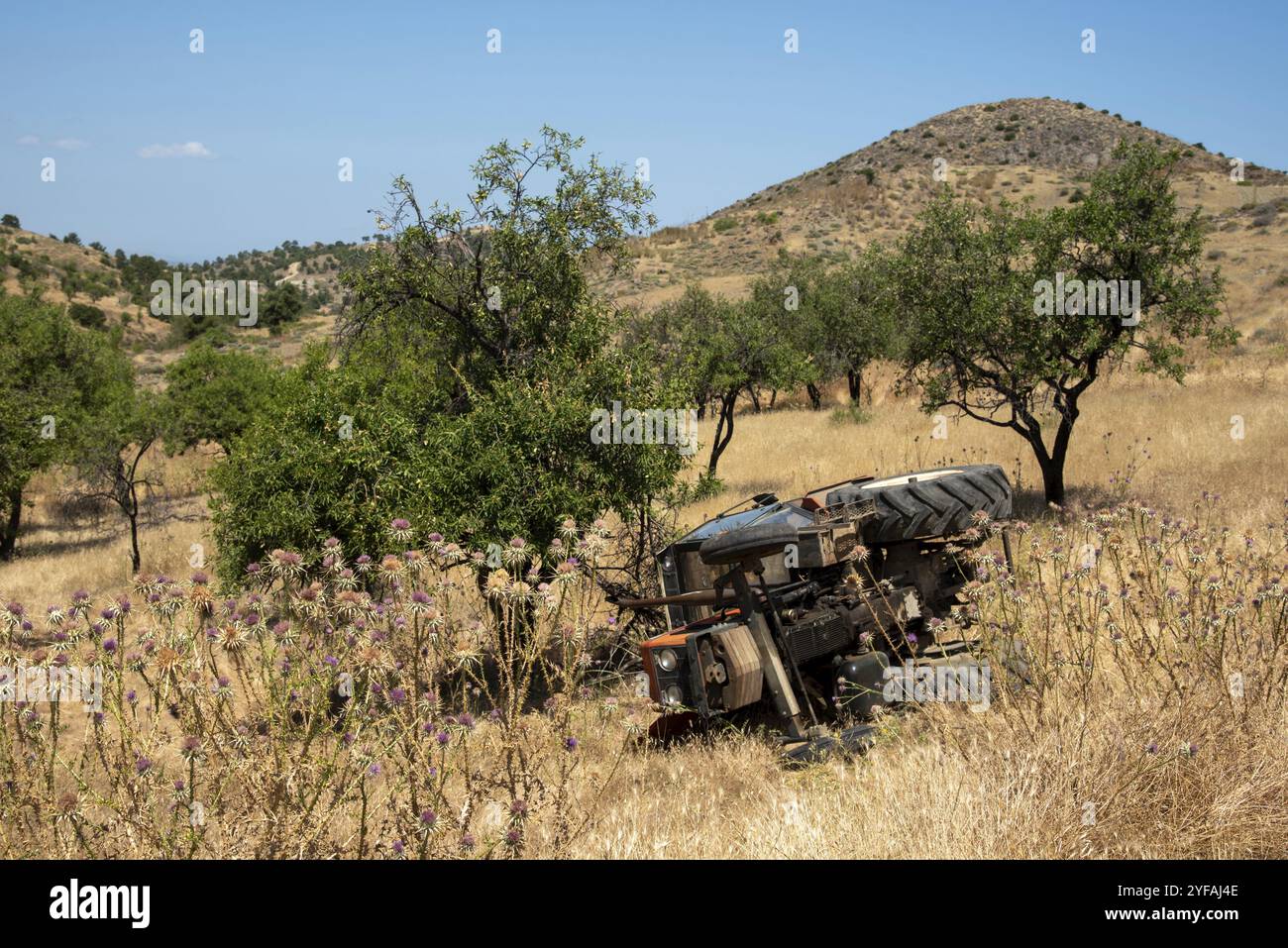 Farm tractor lay into the rural field with trees after accident ...