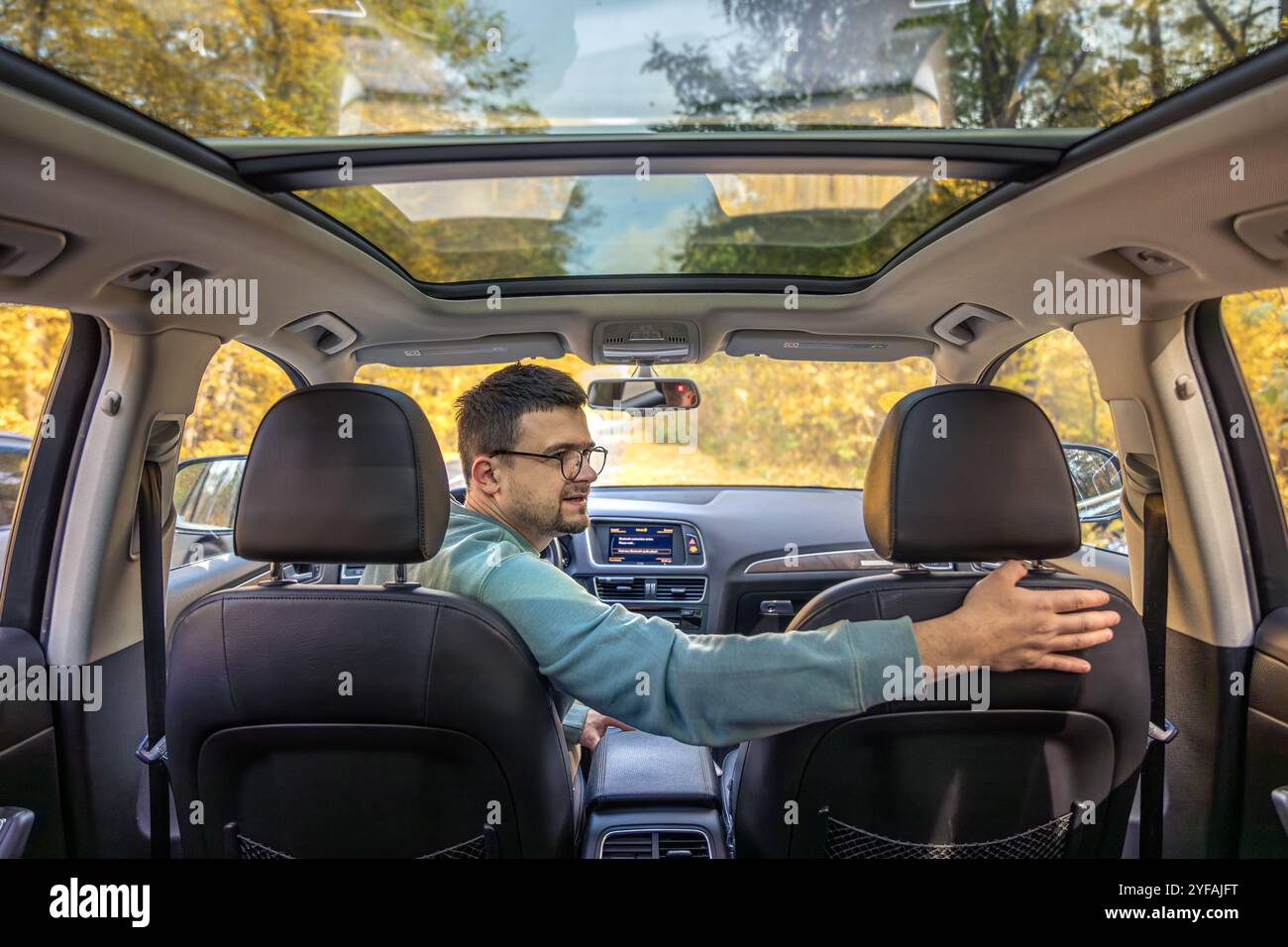 Driving the modern car on asphalt road. A young man drives a car Stock ...