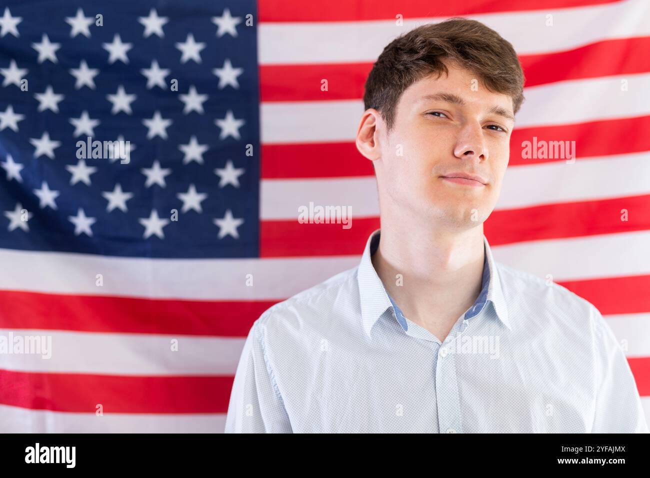 Young guy posing in front of USA flag Stock Photo - Alamy