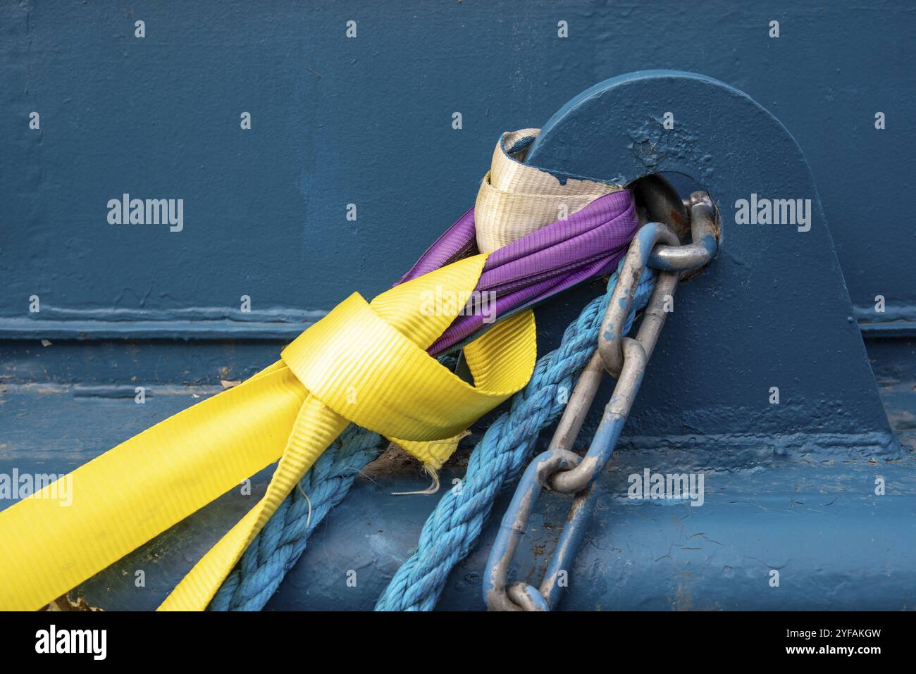 Twisted ship mooring strong rope and metal chain tied on a metal pole ...