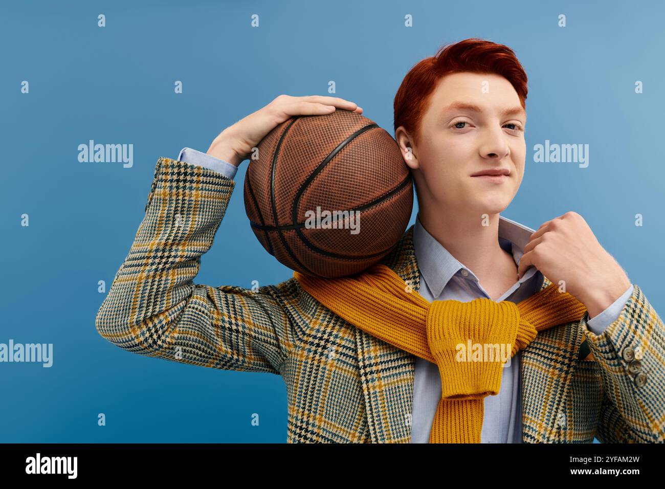 A young man with red hair models a chic layered outfit and confidently ...