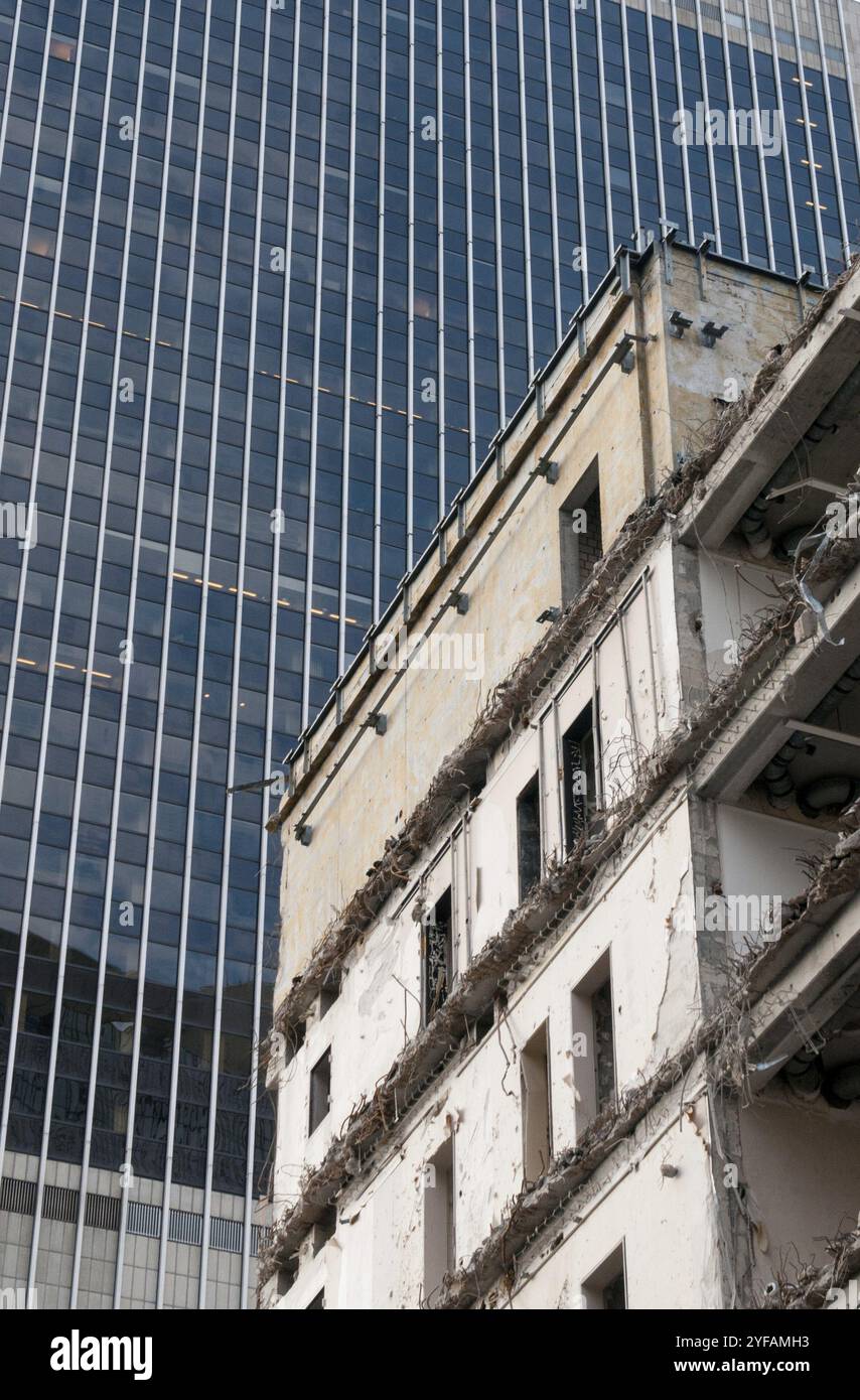 Demolition of an old building opposite to a modern skyscraper office ...