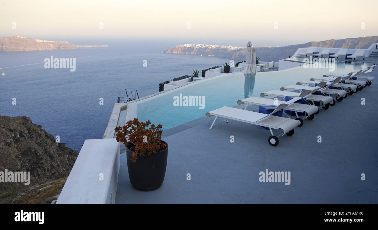 Roof garden of a holiday resort hotel against the ocean at sunset. Oia ...