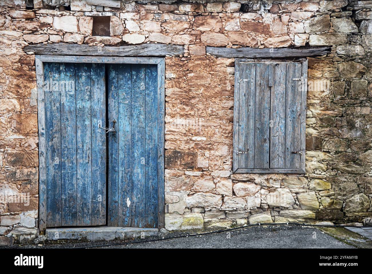 Vintage wooden closed blue door and window on a stoned wall from a ...