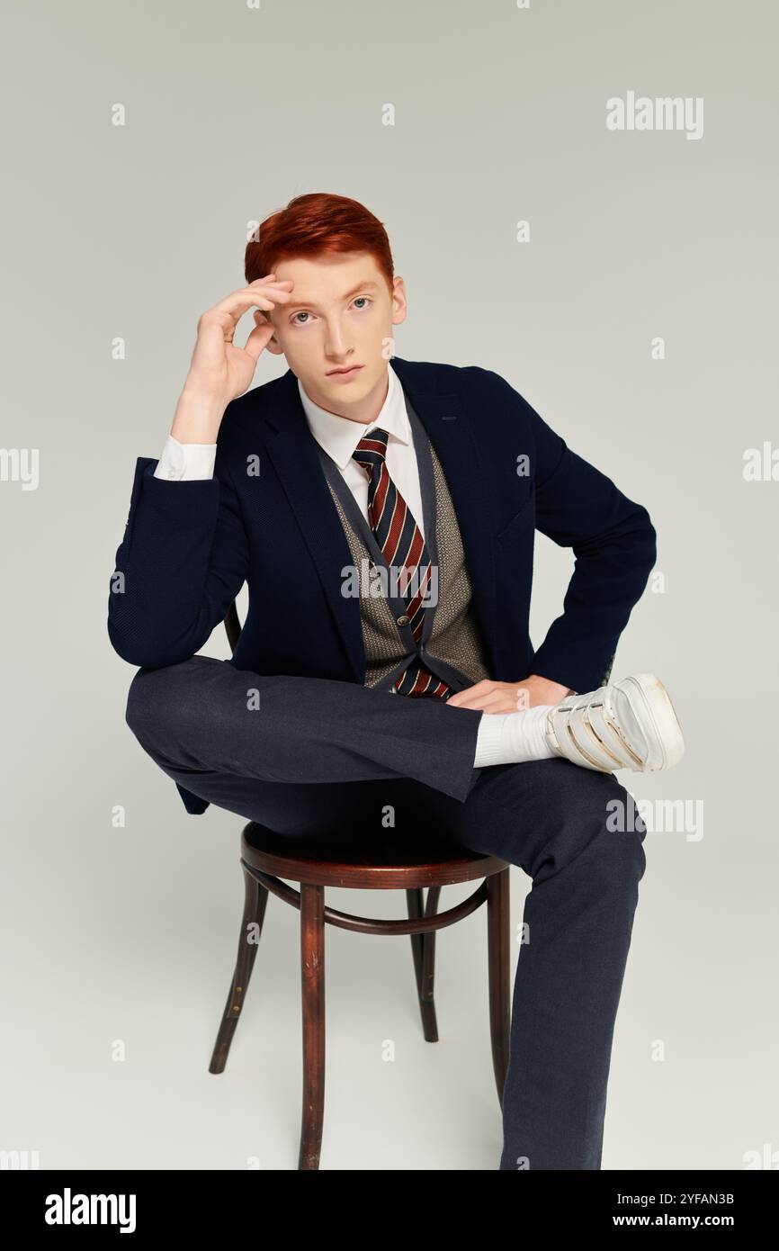 A young student dressed in an elegant winter outfit sits gracefully ...