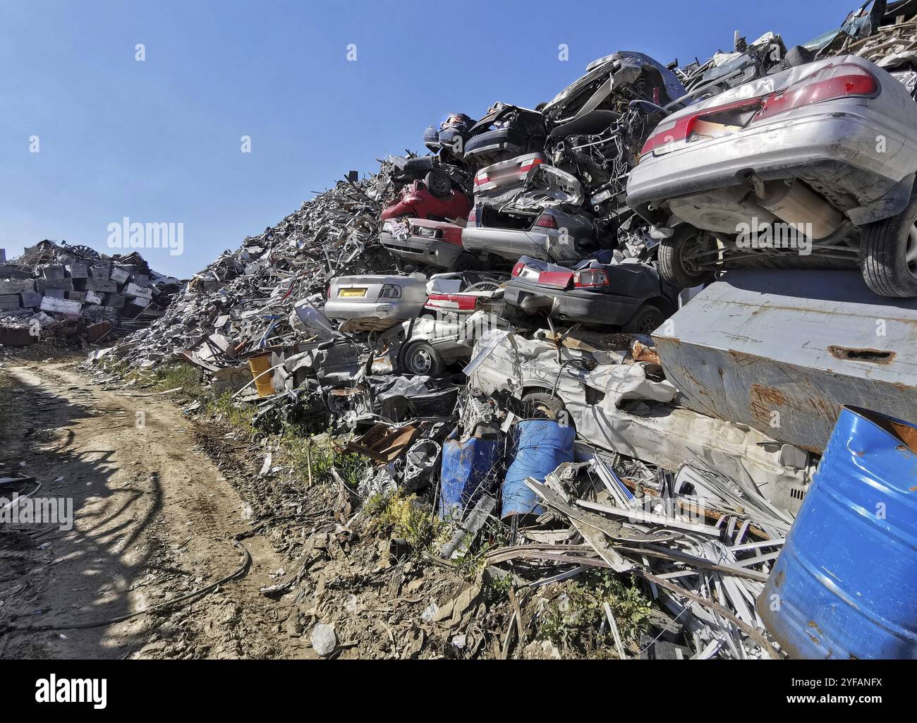 Pile of various scrap cars and other metals on a junk yard field ready ...