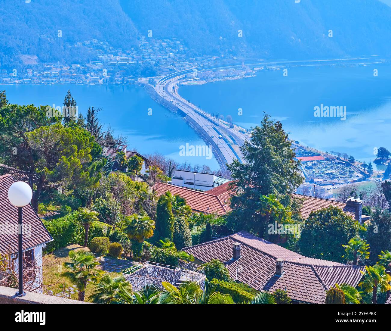 The Alpine landscape with lush gardens of Carona on the mountain slope ...