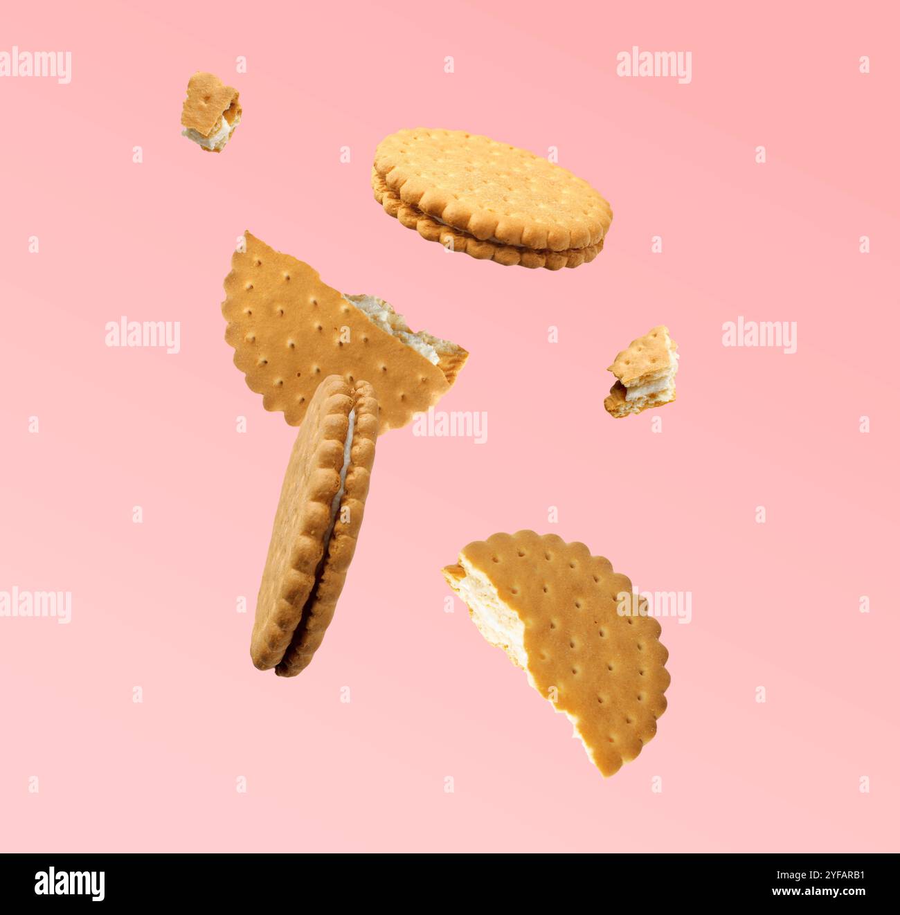 Tasty broken sandwich cookies in air on pink background Stock Photo - Alamy