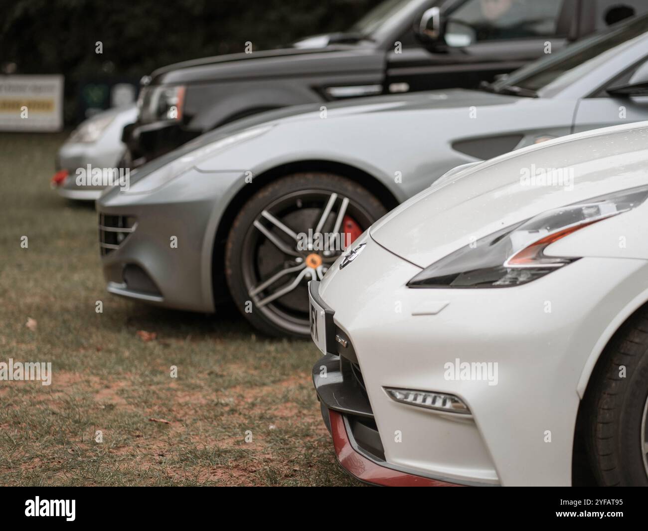 The bonnets of a Honda civic Type R, Range Rover, Ferrari, and Nissan ...