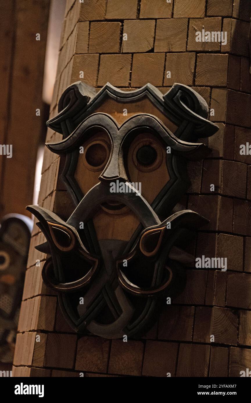 A hand-carved wooden head of Odin mounted on a wall is of the one-eyed ...