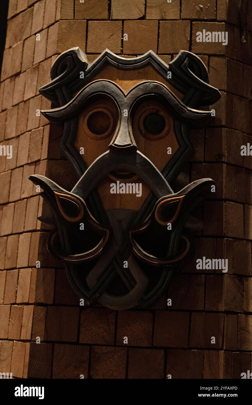 A hand-carved wooden head of Odin mounted on a wall is of the one-eyed ...